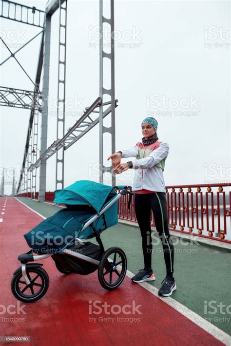 도시의 흐린 날에 아기 마차와 함께 다리에 서서 그녀의 손을 스트레칭 동기 젊은 여성의 전체 길이 샷 건강한 생활방식에 대한 스톡 사진 및 기타 이미지 Istock