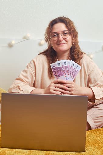 귀여운 여자는 홈 침대에 앉아 유로에 돈을 보유하고 검역으로 인해 격리 중에 원격으로 작동하는 노트북을 가진 소녀 가정 생활에 대한 스톡 사진 및 기타 이미지 Istock