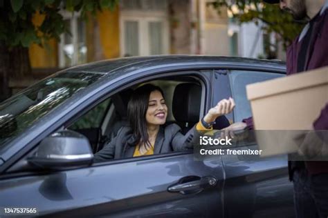 스마트 워치로 지불하고 커브 사이드 픽업에서 차에서 주문을 따기로 지불하는 젊은 미소 짓는 여성 드라이브 스루 픽업에 대한 스톡 사진 및 기타 이미지 Istock