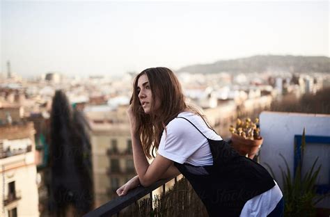 Woman Leaning On Metal Fence On Balcony By Stocksy Contributor Guille Faingold Stocksy