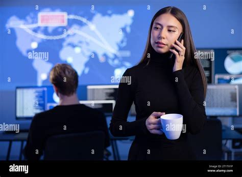 Female Cybersecurity Manager Talking In The Phone In Enterprise Cyber
