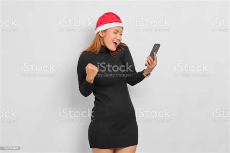 흥분 젊은 아시아 여자 산타 클로스 모자 휴대 전화를보고 흰색 배경에 고립 된 행운을 축하 25 29세에 대한 스톡 사진 및 기타 이미지 25 29세 Brand