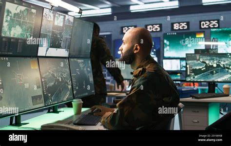 Man Looking At Screens In Military Hq Base Housing Operational Missile