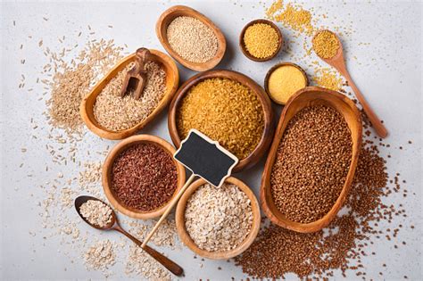 흰색 갈색과 붉은 쌀 메밀 기장 옥수수 그로트 퀴노아와 벌거 밝은 회색 부엌 테이블에 나무 그릇에 글루텐이 함유되지 없는 시리얼 카피스페이스가 있는 정상 보기 0명에 대한