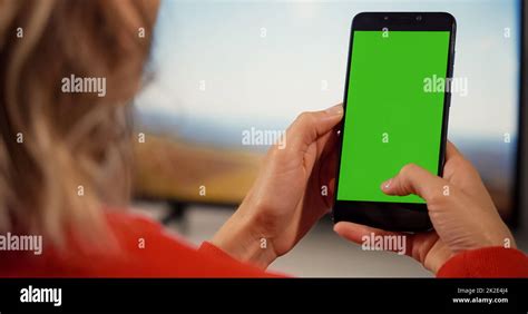 Woman At Home Sitting On A Couch Using Smartphone With Green Mock Up