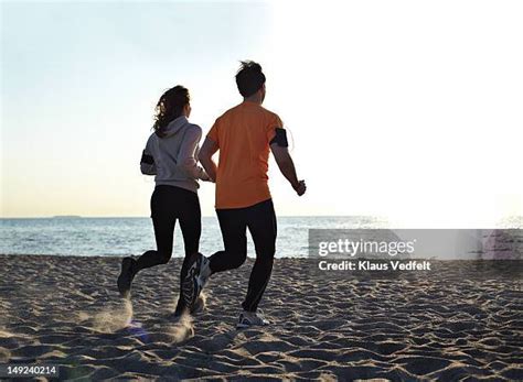 Couple Running On Beach At Sunrise Photos And Premium High Res Pictures