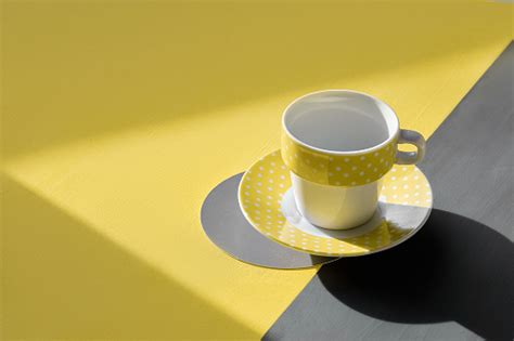 2021년 의 색상인 옐로우와 얼티밋 그레이를 일루미네이션 기하학적 레이어 노란색 회색 배경에 노란색 세라믹 컵 햇빛 긴 그림자