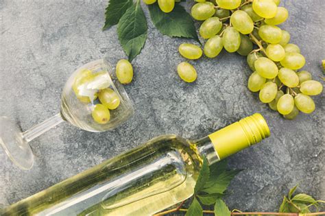 빈티지 그레이 스톤 테이블 배경에 병 화이트 와인 녹색 포도 와인 잔과 잘 익은 포도의 최고 보기 와인 숍 와인 바 와이너리 또는 와인 시음 개념 0명에 대한 스톡 사진 및