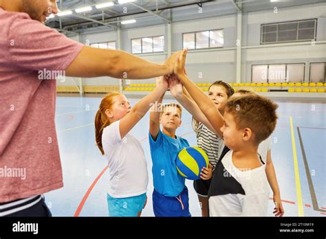 Elementary Students Giving High Five To Teacher During Gym Class Stock