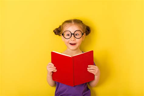 아기 소녀는 책 교과서를 들고 놀랐다 노란 배경에 작은 귀여운 백인 재미 행복 한 미소 아이 아이 어린이 스튜디오 초상화 아이에 대한 스톡 사진 및 기타 이미지 Istock