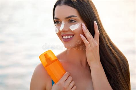 Beautiful Young Woman At Beach Applying Sunscreen On Face Beauty Girl