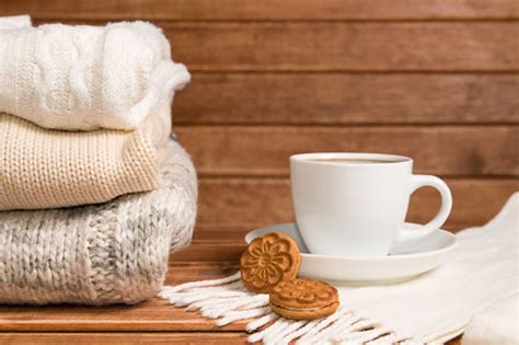 아늑한 니트 따뜻한 스웨터 나무 배경의 스택 레트로 스타일과 핫 초콜릿의 컵에 스웨터 온 정 및 안락의 개념입니다 가을에 대한 스톡 사진 및 기타 이미지 Istock