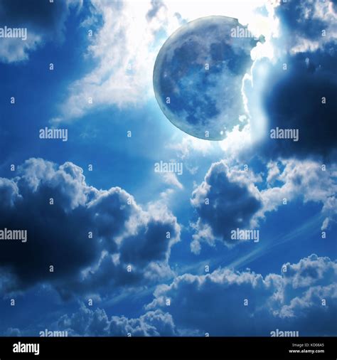 Full Blue Moon Glowing Among The Fluffy Clouds In The Night Sky