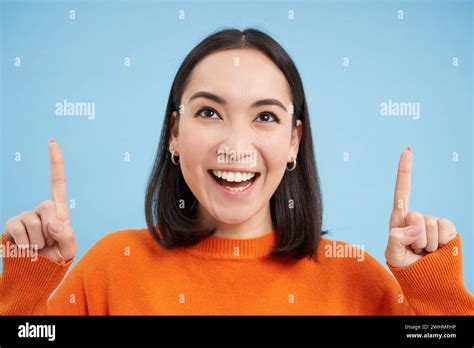 Beautiful Asian Girl Points Fingers Up Shows Banner On Top
