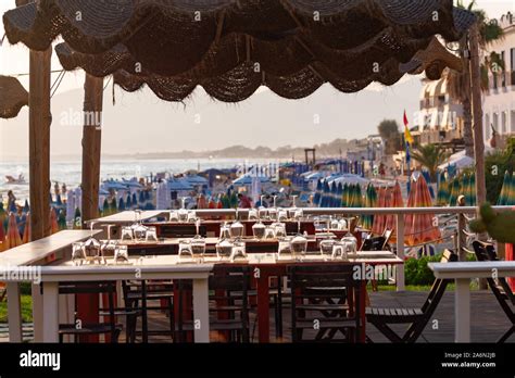Tables In Outdoor Italian Cafe Or Restaurant Served For Dinner On