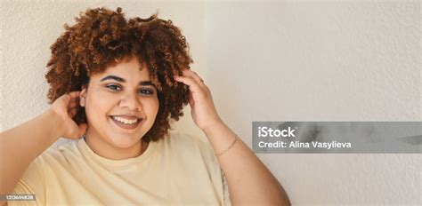 아름다운 행복한 미소 매력적인 플러스 크기 아프리카 흑인 여성 아프로 머리는 흰색 배경에 베이지 색 티셔츠에 포즈를 메이크업