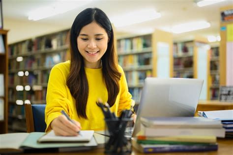Premium Photo Beautiful Asian College Woman Preparing Report Doing Assignments On Laptop In A