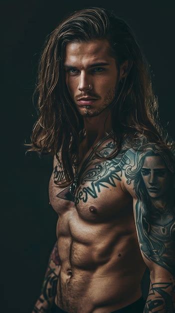 Premium Photo Handsome Bad Boy With Long Hair And Tattoos Striking A Pose