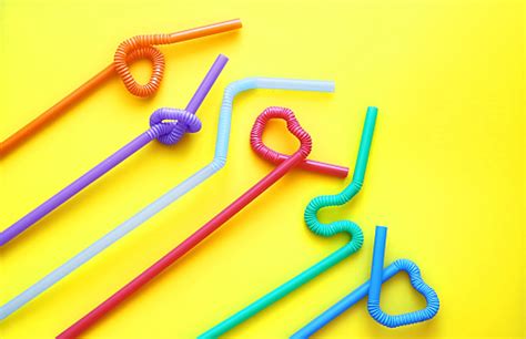 그들은 노란색 배경에 매듭이나 지그재그 또는 심장 모양으로 비틀 수 있기 때문에 유연한 부분과 색상 플라스틱 칵테일 튜브 공간을 복사합니다 에코 컨셉 0에 대한 스톡 사진