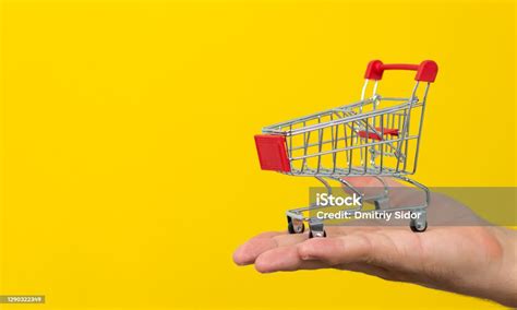 노란 배경 위에 작은 쇼핑 카트 트롤리를 들고 있는 남성 손 온라인 쇼핑 및 빠른 배송 컨셉 개념에 대한 스톡 사진 및 기타 이미지 Istock