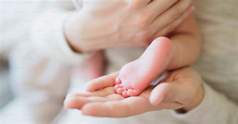 알아볼 수 없는 어머니는 갓 태어난 아들을 팔에 안고 다리와 손을 닫습니다 사진 Unsplash의 아이 이미지