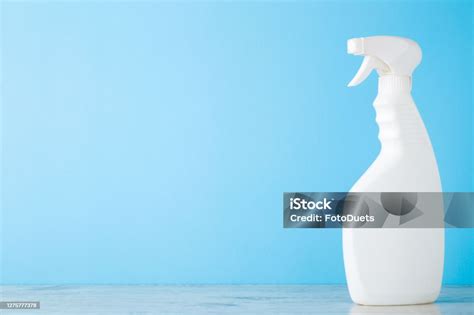 밝은 파란색 벽 배경에 선반에 흰색 스프레이 병 하나 파스텔 색상 부엌 욕실 및 기타 객실의 다른 표면에 대한 세제 근접 촬영 전면 보기입니다 텍스트 또는 로고의 빈