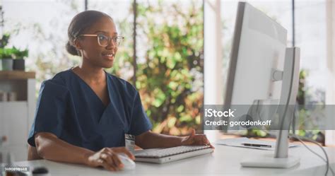 일상적인 병원 운영을 위해 데스크톱 컴퓨터를 사용하는 아프리카 의료 간호사 공공 의료 시설의 현대 사무실에서 온라인 의료 작업을