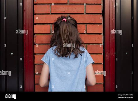 Girl Standing Backwards Against Brick Wall Outdoors Copy Space Stock