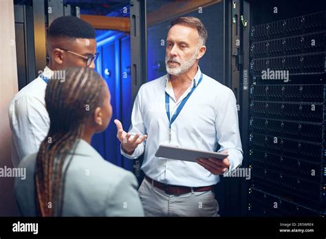 Building And Maintaining Big Data Infrastructure A Group Of Technicians Using A Digital Tablet