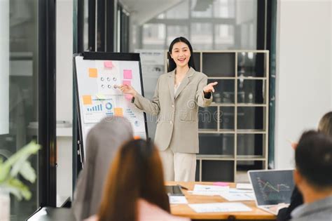 Confident Businesswoman Presenting Data Charts And Graphs During An Office Meeting Stock Image