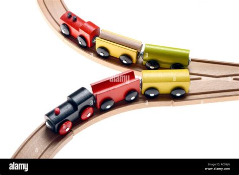 Two Toy Wooden Trains Moving In Different Directions After Passing A