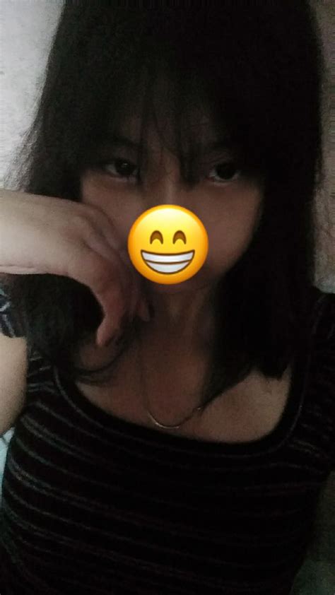 A Woman Holding An Emoticive Smiley Face Up To Her Face With Both Hands