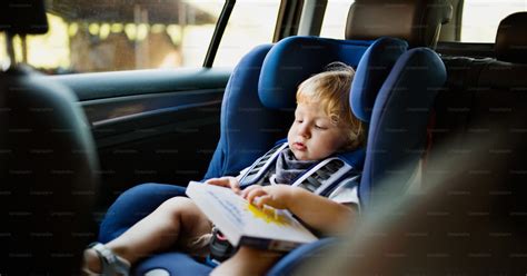 차의 카시트에 앉아 있는 귀여운 소년 책을 들고 있는 유아 사진 Unsplash의 의자 이미지