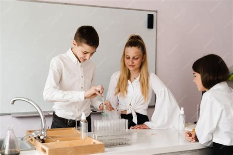 실험실 교육 개념 학교에서 화학 수업을 공부하는 학생 그룹에서 실험을 위해 액체가 든 플라스크를 들고 있는 학생 프리미엄 사진