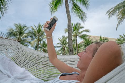 열 대 기후사람들이 여행 모바일 장치 기술에서 멋진 순간을 포착 하는 자연과 인생을 즐기는 휴가에 편안한 흰색 해먹에 Selfie를 복용 하는 젊은 여자 공유 개념에 대한