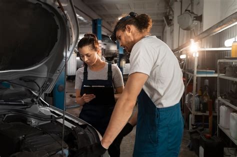 Mecánicos Masculinos Y Femeninos Que Trabajan En La Tienda De Un
