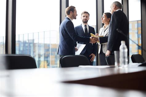 컨퍼런스에서 새로운 비즈니스 지 점점 콘텐츠 기쁘게 젊은 수염된 사업가 성숙한 감독과 악수를 하 고 비즈니스 포럼 후 동료에 게 이야기 비즈니스에 대한 스톡 사진 및 기타