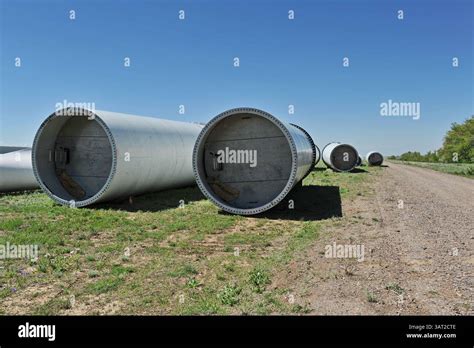new parts of wind turbines are laid out in an open field for subsequent