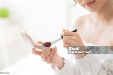 침실에 브러쉬 뺨으로 메이크업을 적용 얼굴을 찾고 거울 블러셔 얼굴 스킨 케어 및 화장품 개념을 들고 아름다운 소녀와 미소 젊은