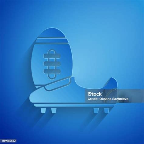 파란색 배경에 격리 스파이크 아이콘 종이 컷 축구 또는 축구 신발 미식 축구 부츠와 공 종이 아트 스타일입니다 벡터 일러스트레이션 가죽에 대한 스톡 벡터 아트 및 기타