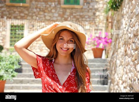 Beautiful Tourist Girl With Hat And Red Dress Posing On Cozy Italian