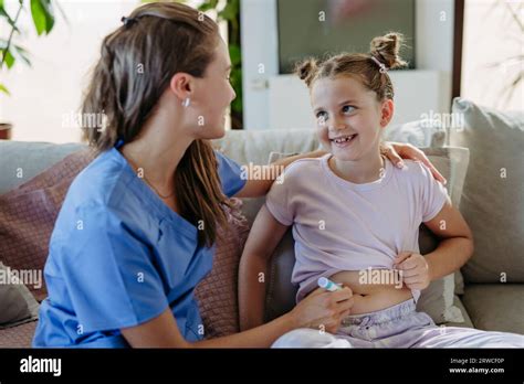 Nurse Applying A Continuous Glucose Monitor Sensor To The Arm Of A Diabetic Girl Stock Photo Alamy