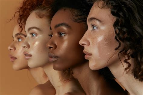 Four Diverse Women With Glowing Skin Pose In Profile Against A Warm