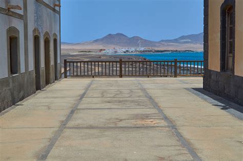 푸에르토 데 라 크루즈 푼타 얀디아 푸에르테벤투라 카나리아 제도 스페인의 파도가 있는 풍차와 해변이 있는 어촌 마을의 전경 건조