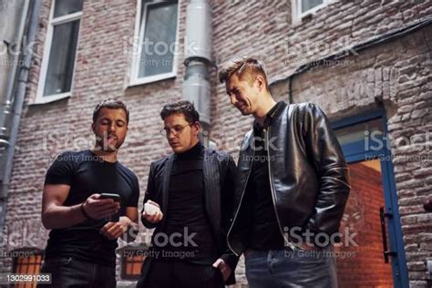 스마트 폰으로 몇 가지 재미있는 물건 세 명의 남자 친구가 술집 밖에 서 있다 대화를 나눌 수 있습니다 좋은 옷에 20 24세에 대한 스톡 사진 및 기타 이미지 Istock