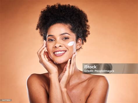 스킨케어 뷰티 흑인 여성이 갈색 배경에 보습을 위해 스튜디오에서 페이스 크림을 들고 있다 인물 미소 행복한 여성 모델 페이셜 로션 크림 또는 건강한 피부를 위한 화장품 제품