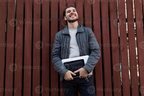 Happy Man Businessman With A Laptop In His Hands Looks Dreamily Up On