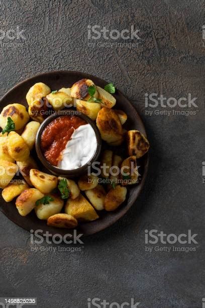 스페인 타파의 평면도 Patatas Bravas 튀긴 감자는 매운 토마토 소스와 아이올리를 콘크리트 테이블에 곁들입니다 0명에