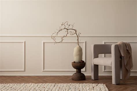 복사 공간 현대적인 안락 의자 베이지 색 격자 무늬 가지가있는 꽃병 나무 커피 테이블 꼰 깔개 및 개인 액세서리가있는 우아한