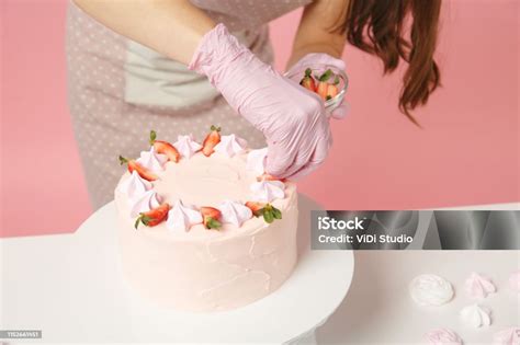 스튜디오에서 분홍색 파스텔 배경에 고립 된 테이블에 요리 하는 앞치마 흰색 T 셔츠에 자른 요리사 요리 제과 제빵 사가 닫습니다